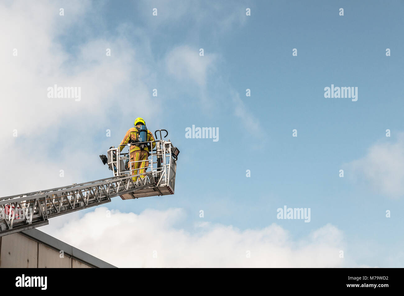 fireman at work standing high on a ladder Stock Photo - Alamy