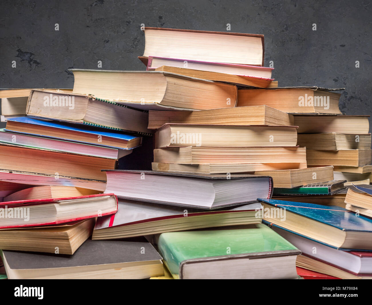 Closeup of pile of old books over gray wall Stock Photo - Alamy