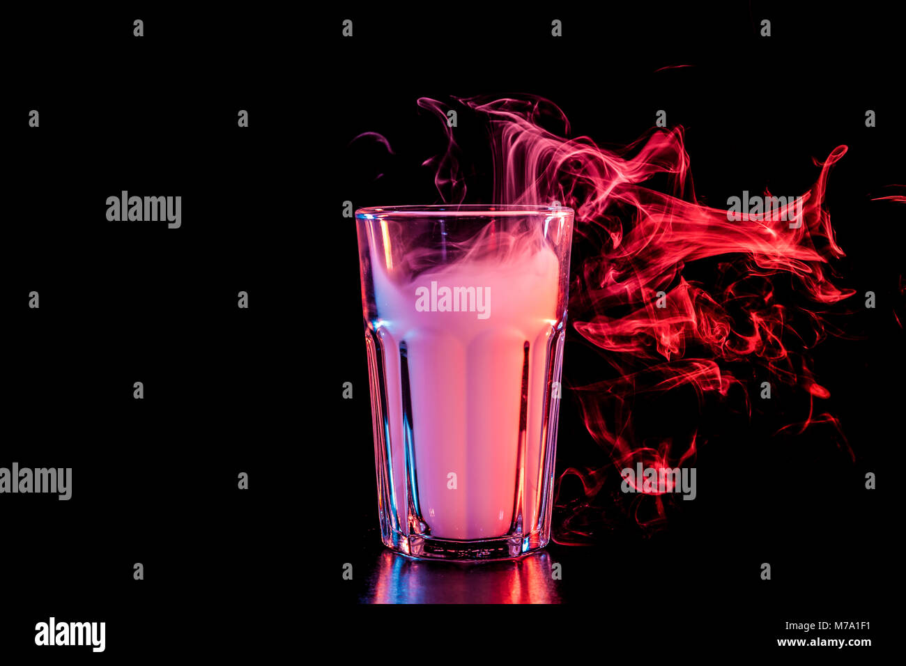 A transparent glass filled with a cloud from a red vape smokes and ...