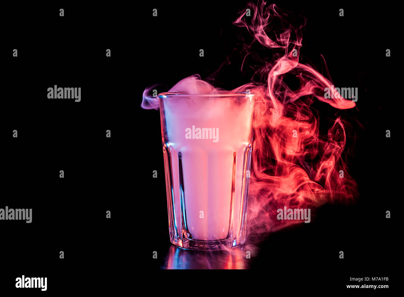 A transparent glass filled with a cloud from a red vape smokes and ...