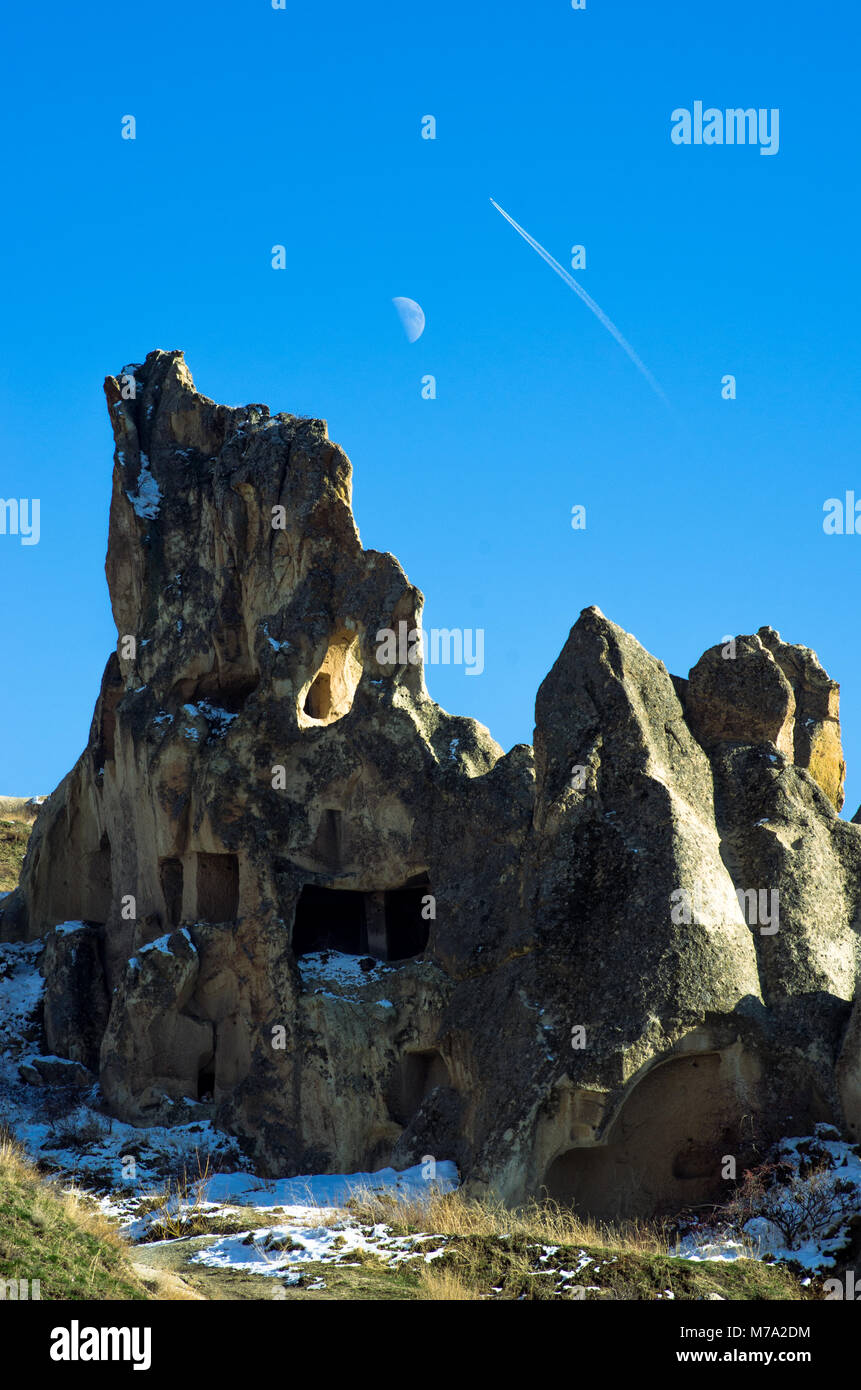 Moon and plane trail in the sky overhanging the lunar landscape of ...