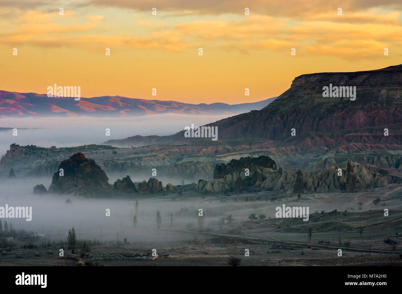 Orange sunset and mystical fog over the Cappadocia, Turkey Stock Photo ...