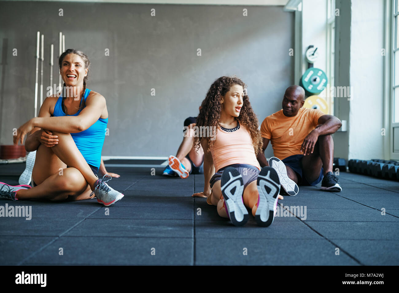 Diverse group of fit people in sportswear smiling and stretching ...