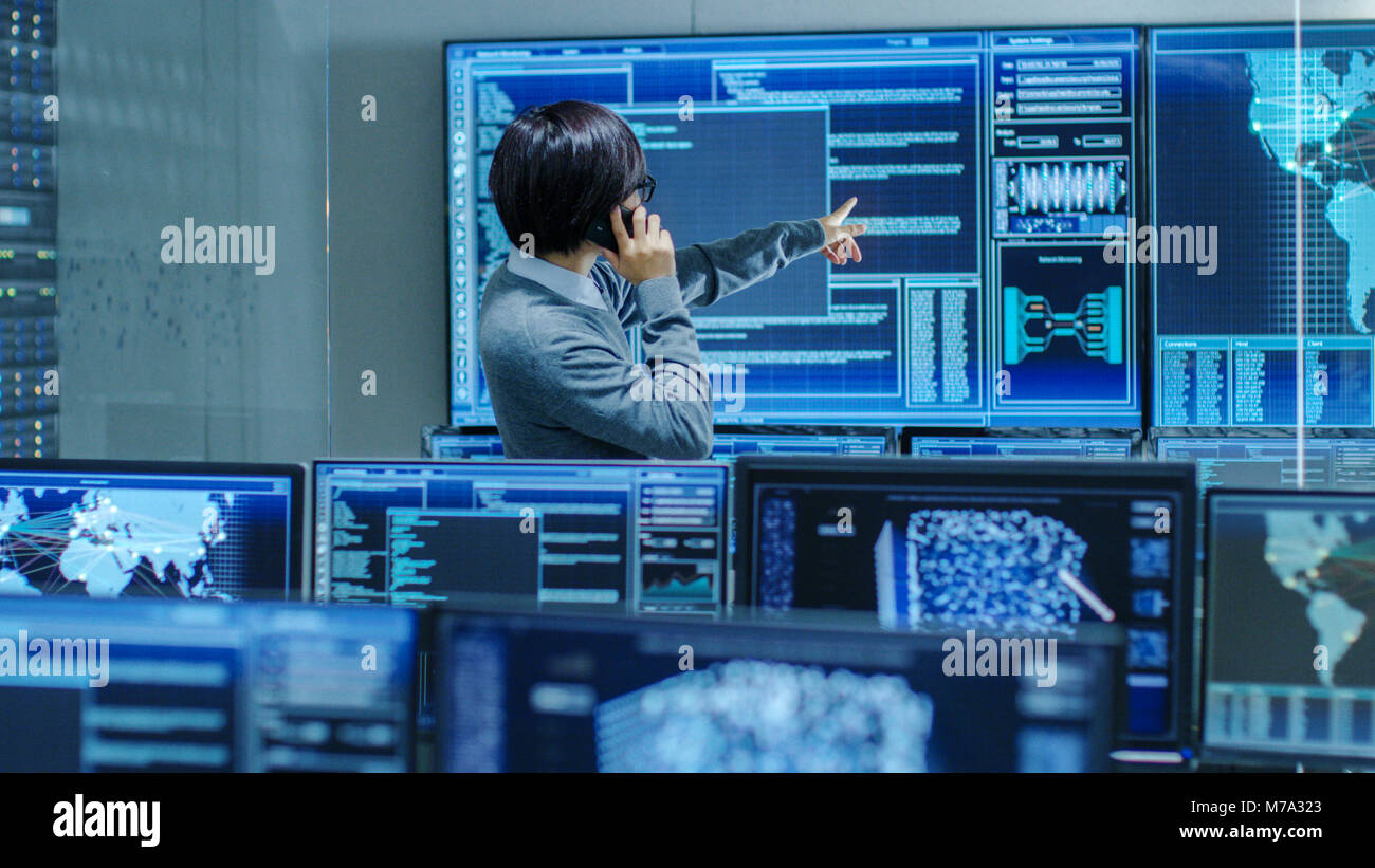 In the System Control Room IT Administrator Talks on the Phone. He's in ...
