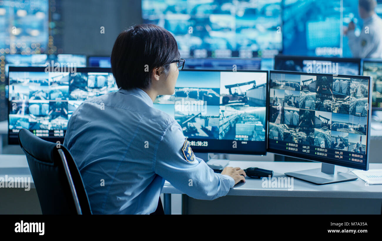 In the Security Control Room Officer Monitors Multiple Screens for ...