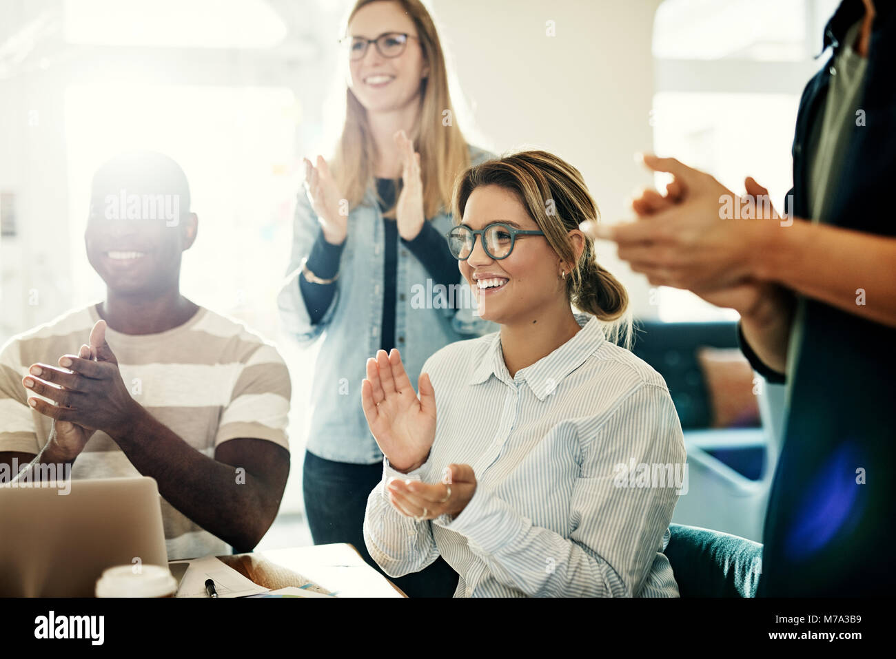 Group of diverse work colleagues clapping during a presentation while ...