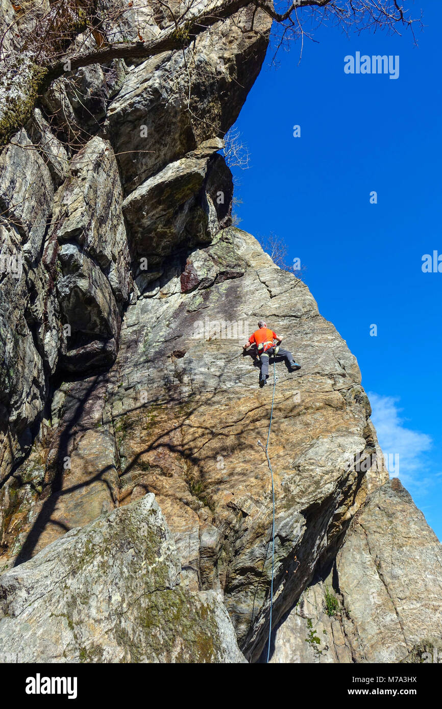 Male rock climber in red on granite cliff, Ariege, French Pyrenees ...