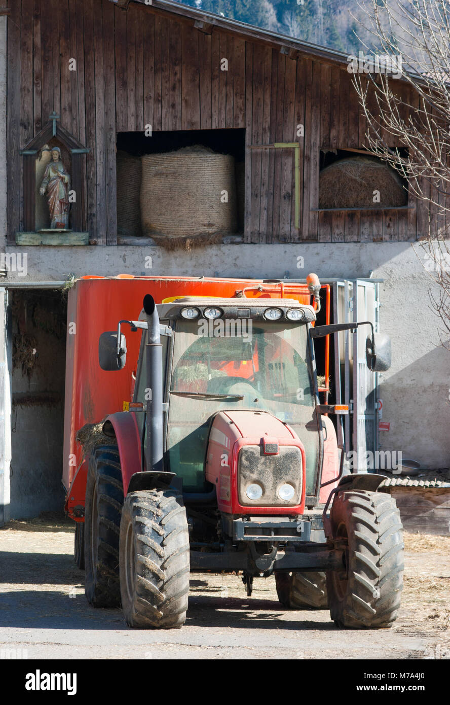 Red tractor that produces and stores the bales of hay Stock Photo - Alamy