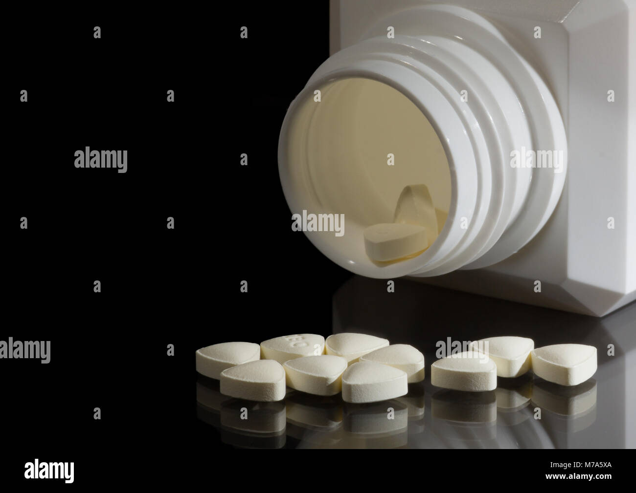 Medication pills isolated on a black background Stock Photo - Alamy