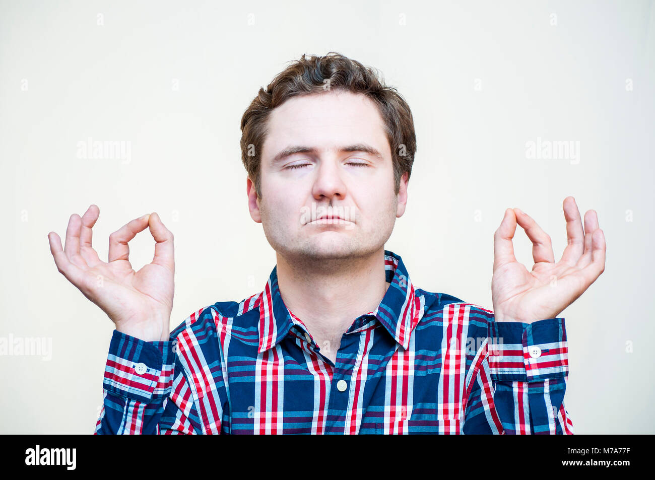 Portrait of young tranquil meditating man on white background Stock ...