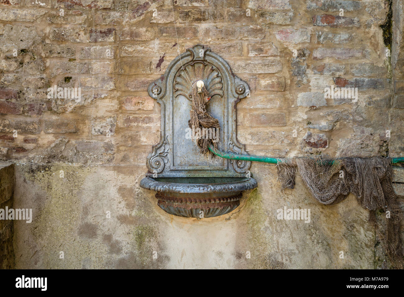 rusty iron fountain on old scraped wall Stock Photo - Alamy