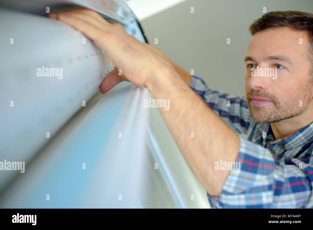 Handyman installing a window shutter Stock Photo - Alamy