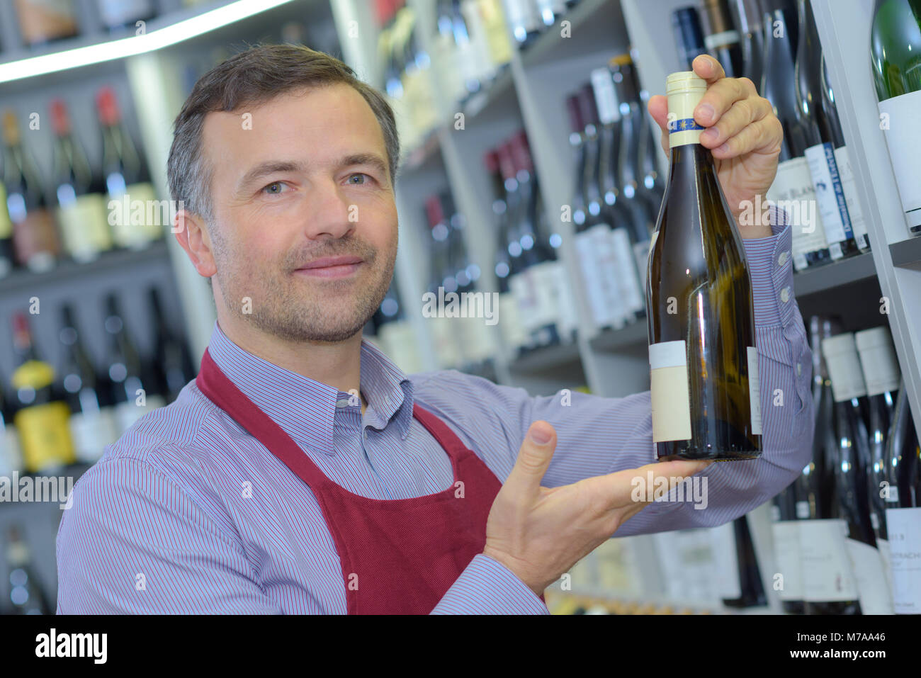confident male sommelier examining wine bottle Stock Photo - Alamy