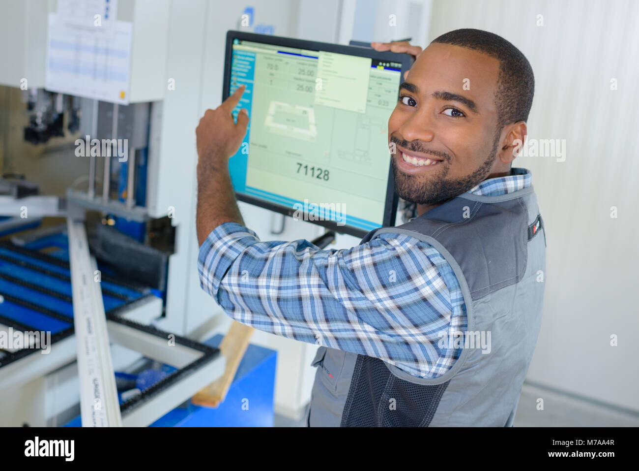 Workman pointing to computer screen Stock Photo - Alamy