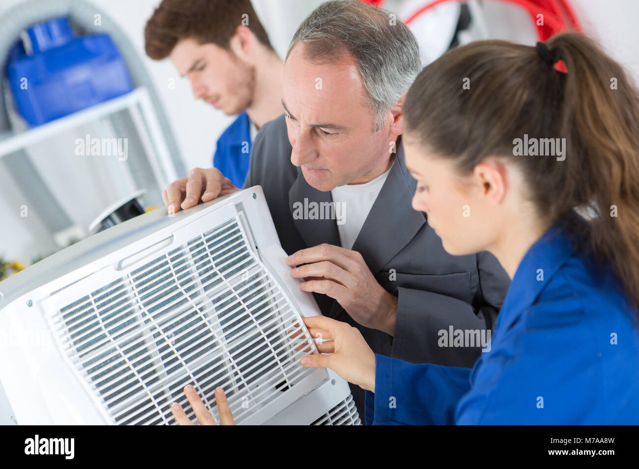 Team working on air conditioning unit Stock Photo - Alamy