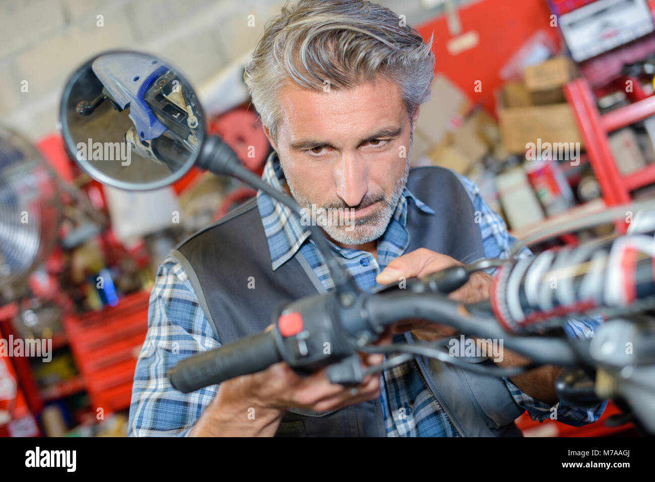 Mechanic working on scooter Stock Photo - Alamy