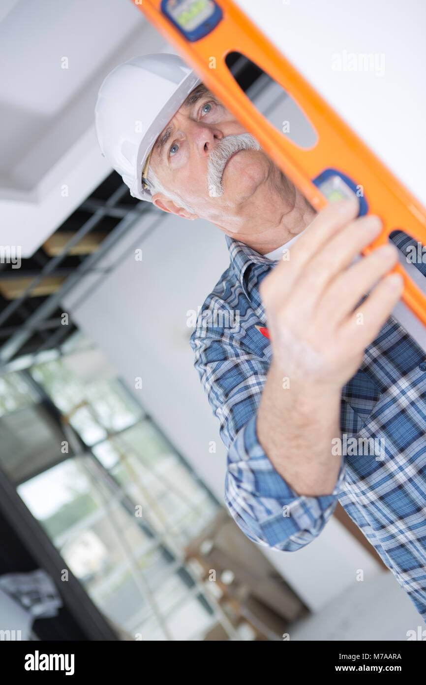 builder holding building level Stock Photo - Alamy