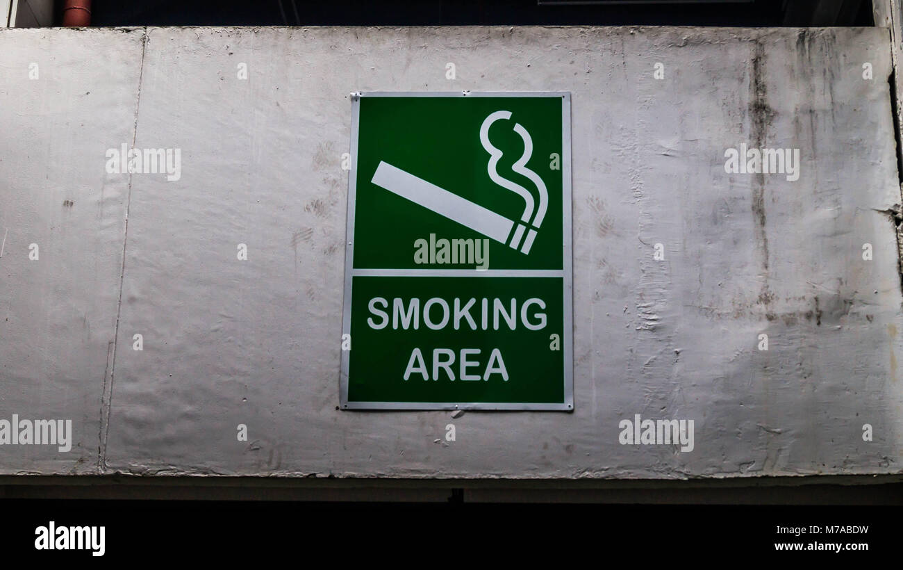 smoking designated area sign mounted in the wall in open space Stock ...