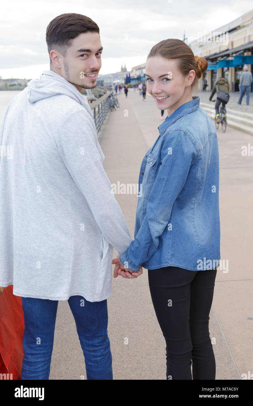 young couple holding hands while wandering in the city Stock Photo - Alamy