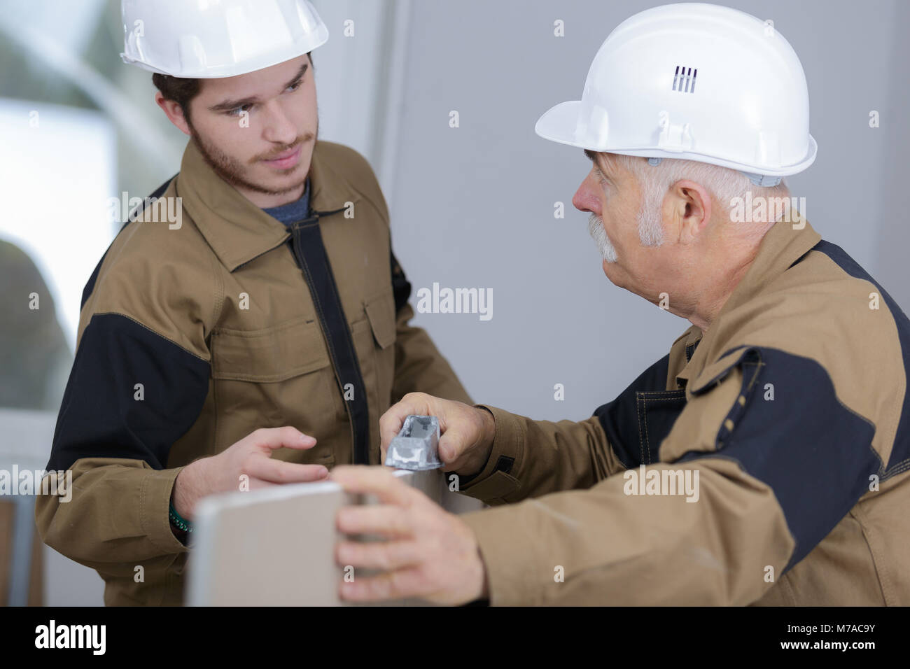 senior foreman is sharing his ideas with young builder Stock Photo - Alamy