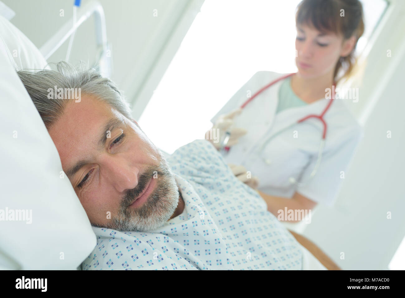 sad man in bed in hospital feeling ill Stock Photo - Alamy