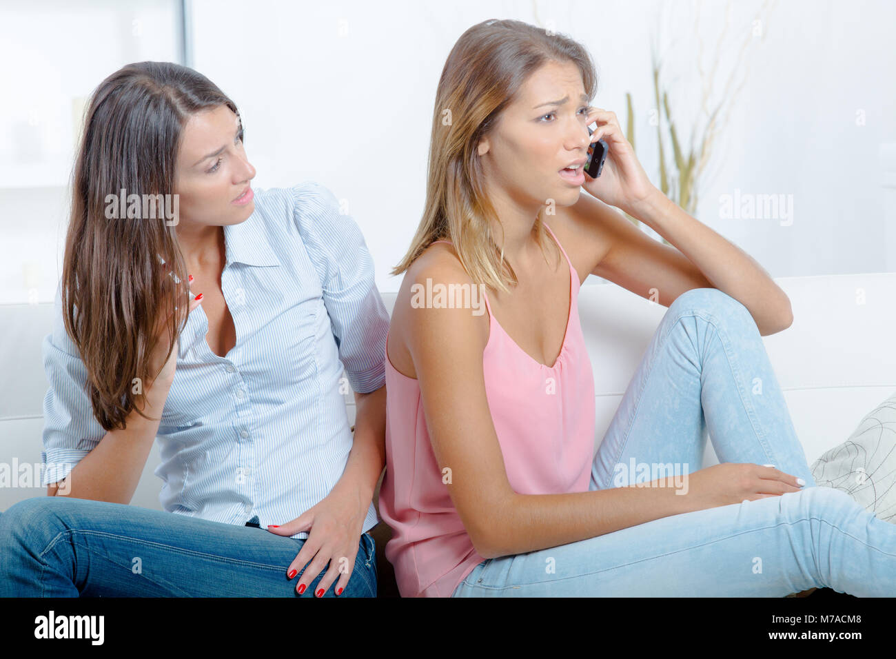 two disappointed friends having bad news on the phone Stock Photo - Alamy