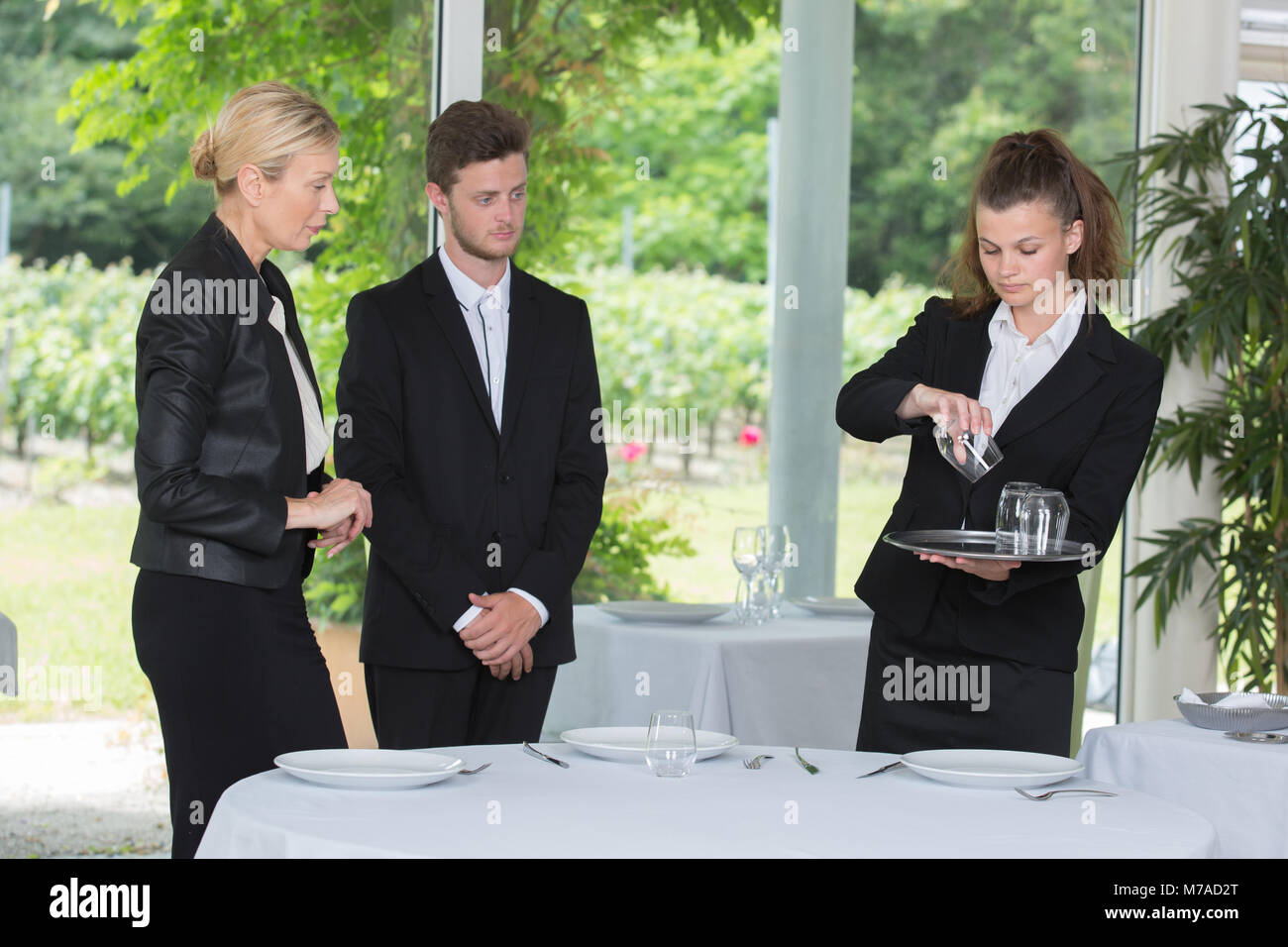 Waitress setting table Stock Photo - Alamy