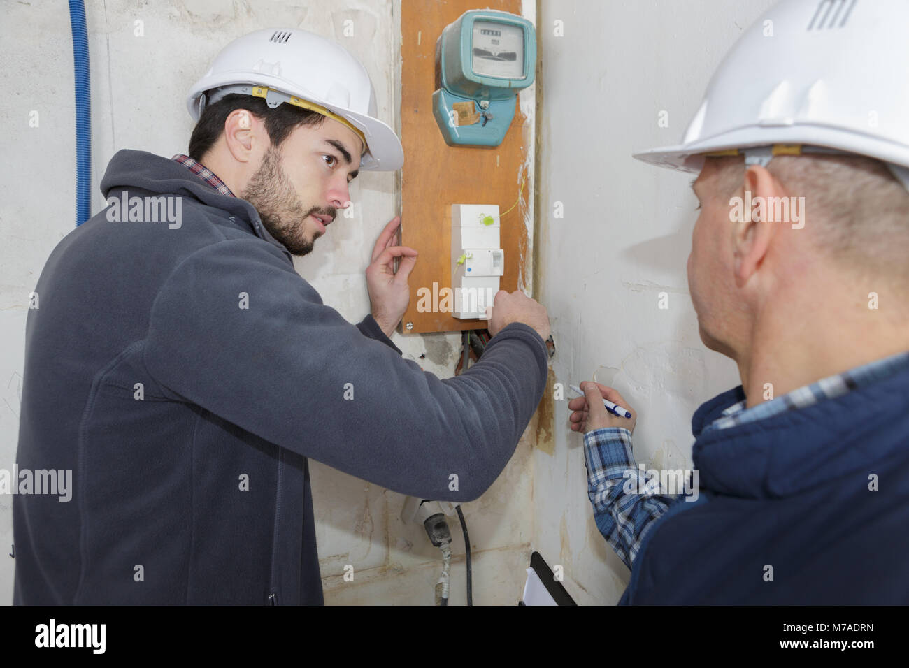 two electricians standing next to fuse board Stock Photo - Alamy