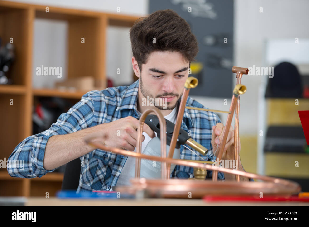 young plumber using welding gas torch to solder copper pipes Stock ...