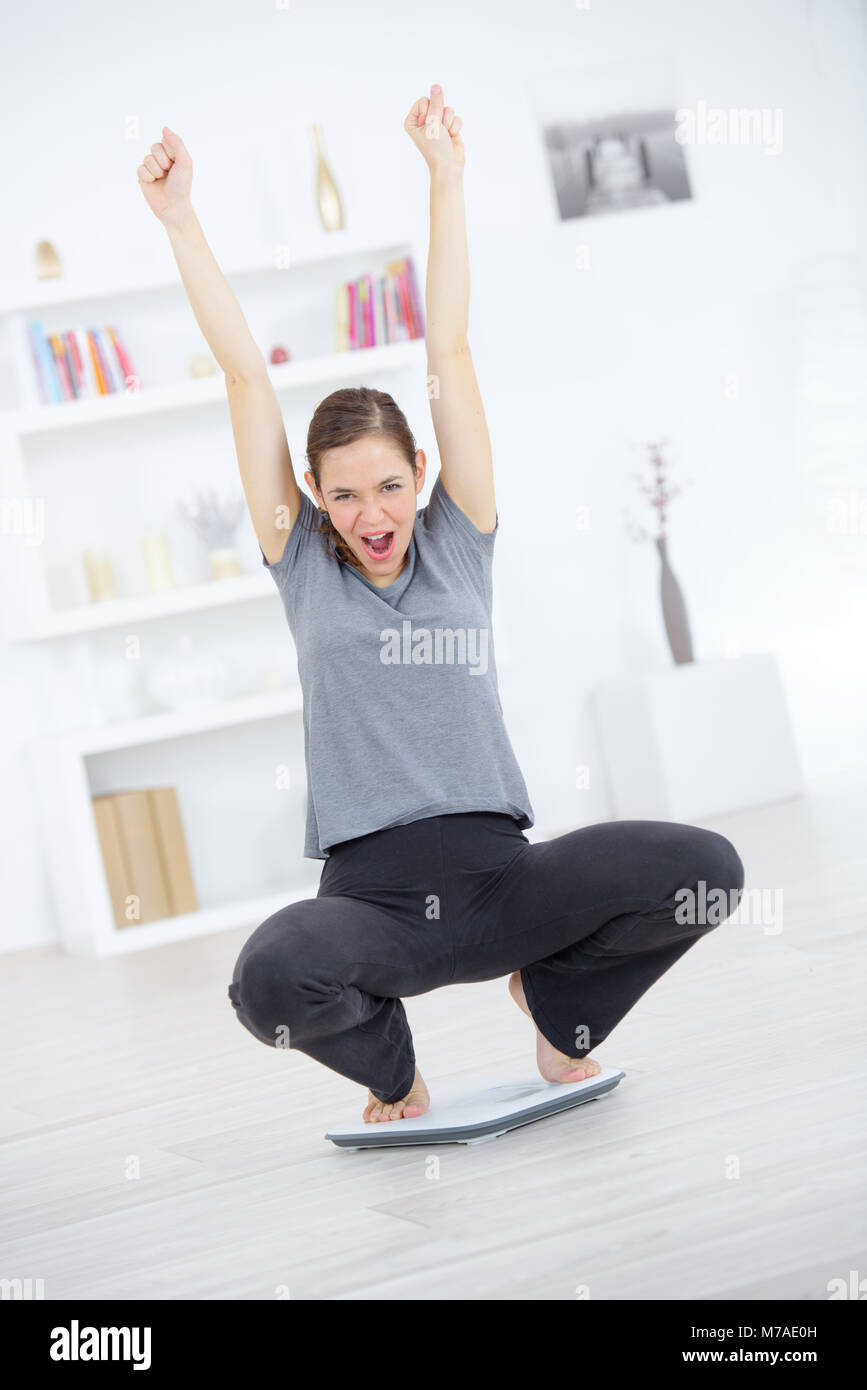 woman on bathroom scales making triumphant gesture Stock Photo - Alamy