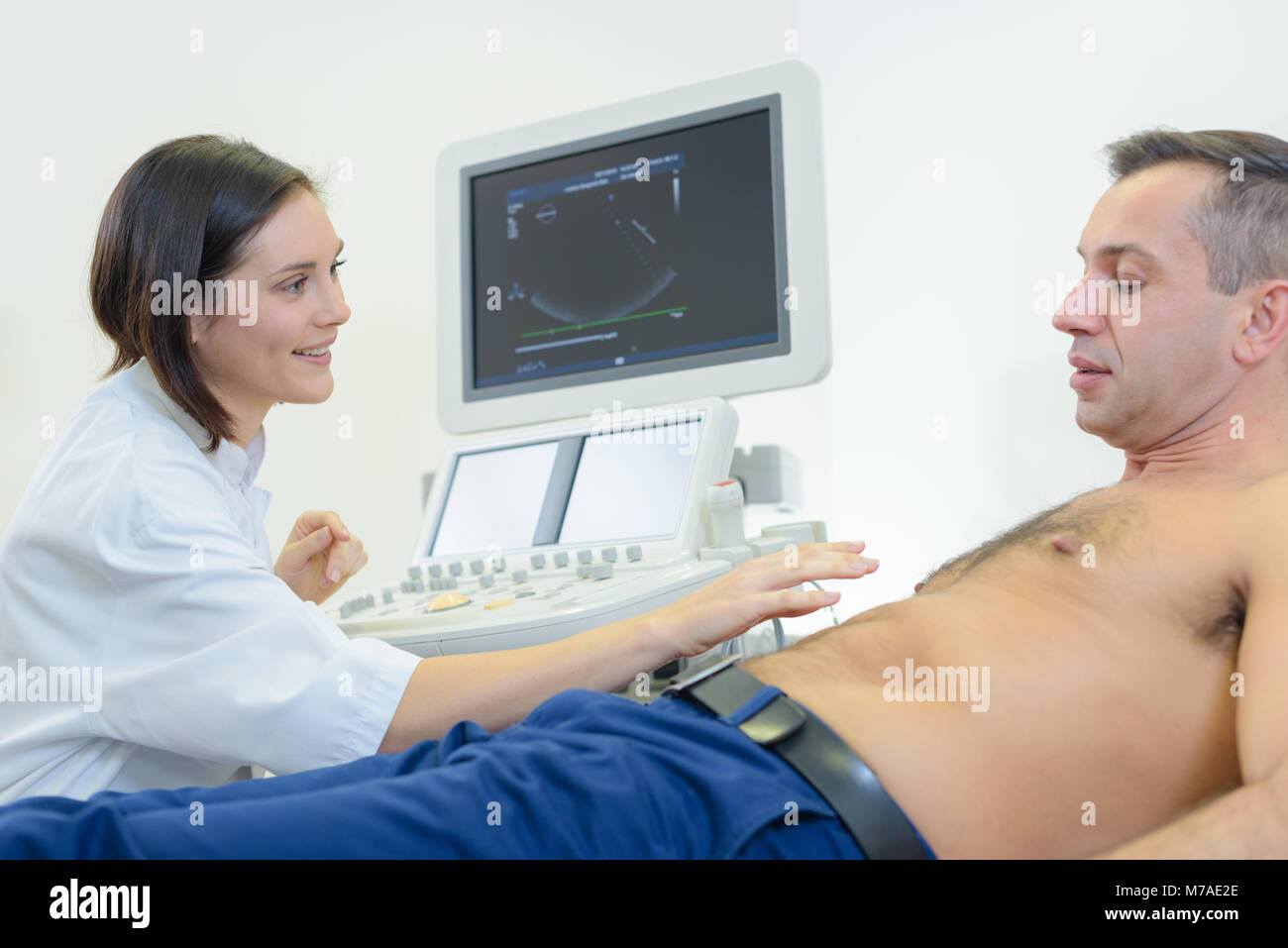 doctors is holding a probe while performing abdominal ultrasound exam ...