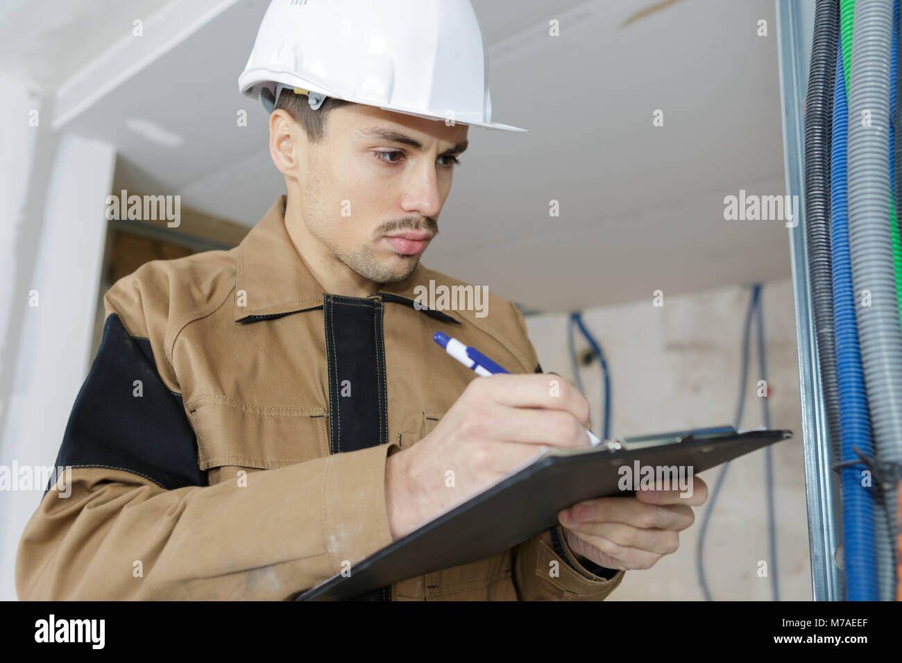 engineer in act of note record in a construction site Stock Photo - Alamy