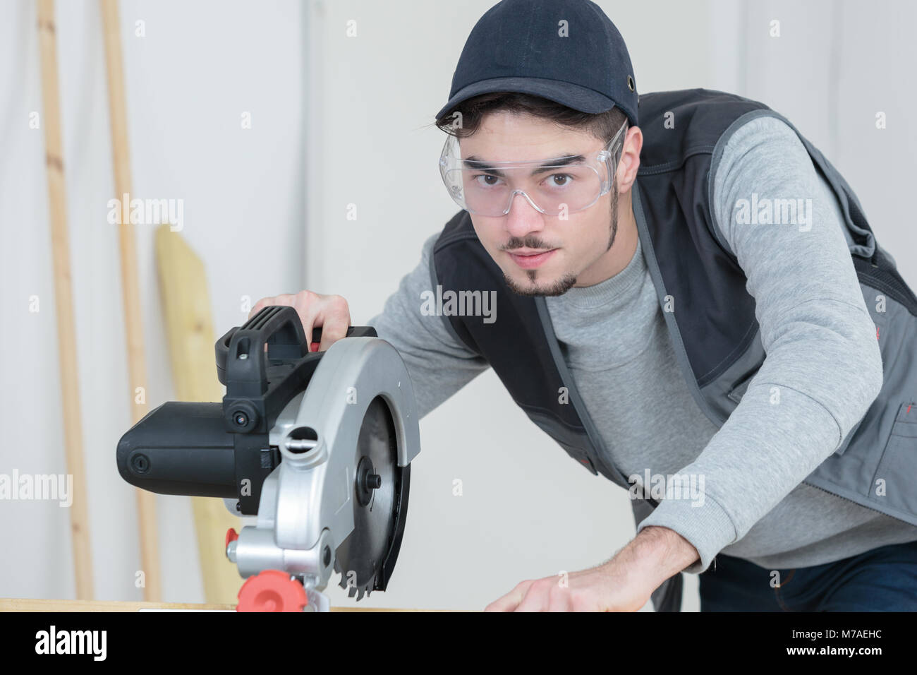 Young man using circular saw Stock Photo - Alamy