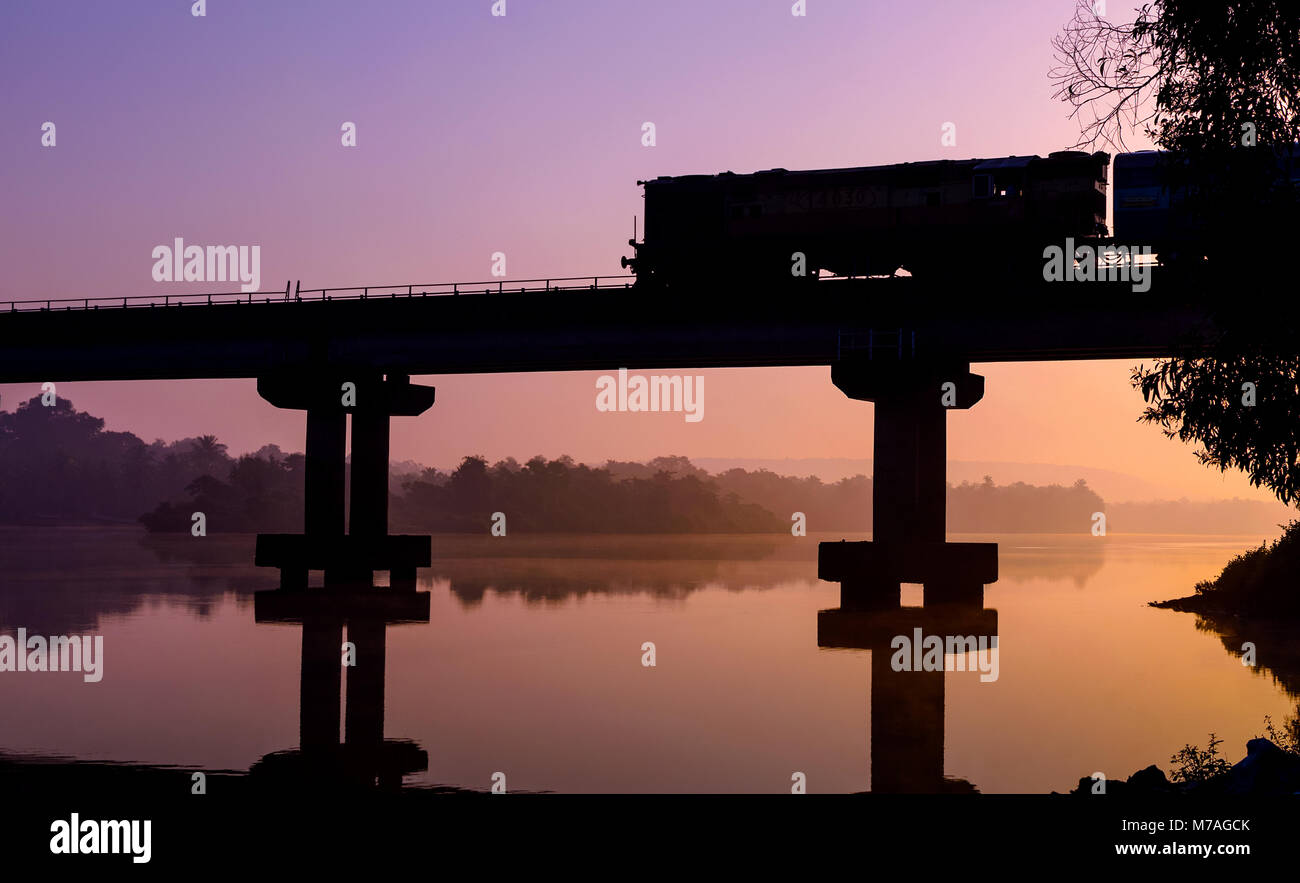 Train passing by on a bridge on water. Made for a good silhouette Stock ...