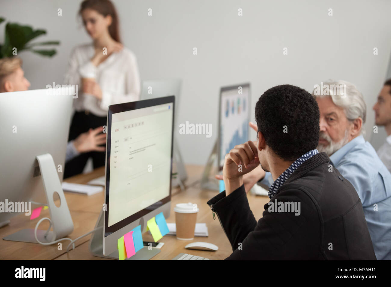 Focused african manager discussing project with senior colleague Stock ...