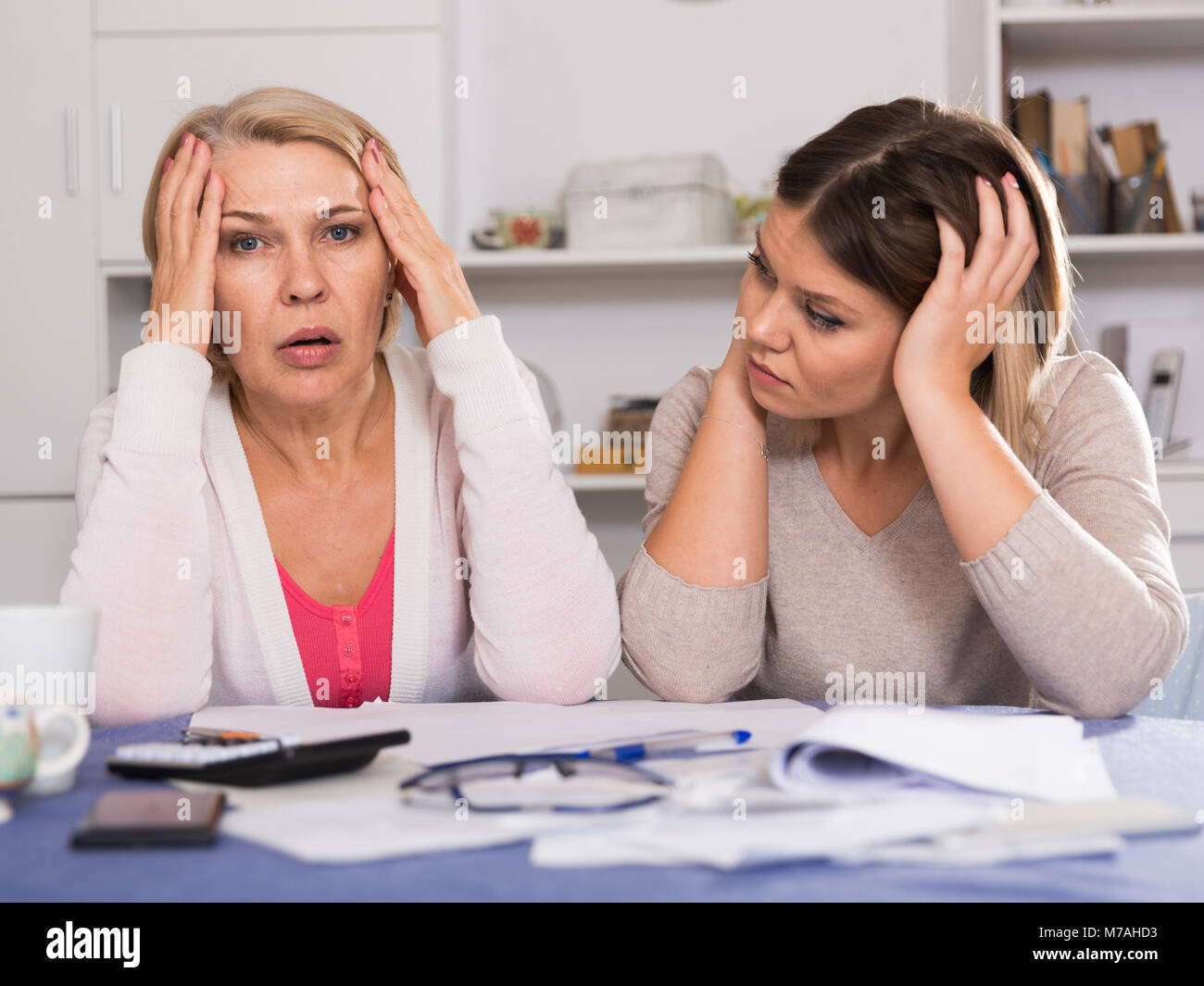 Sad mother and her adult daughter with big financial problems are ...