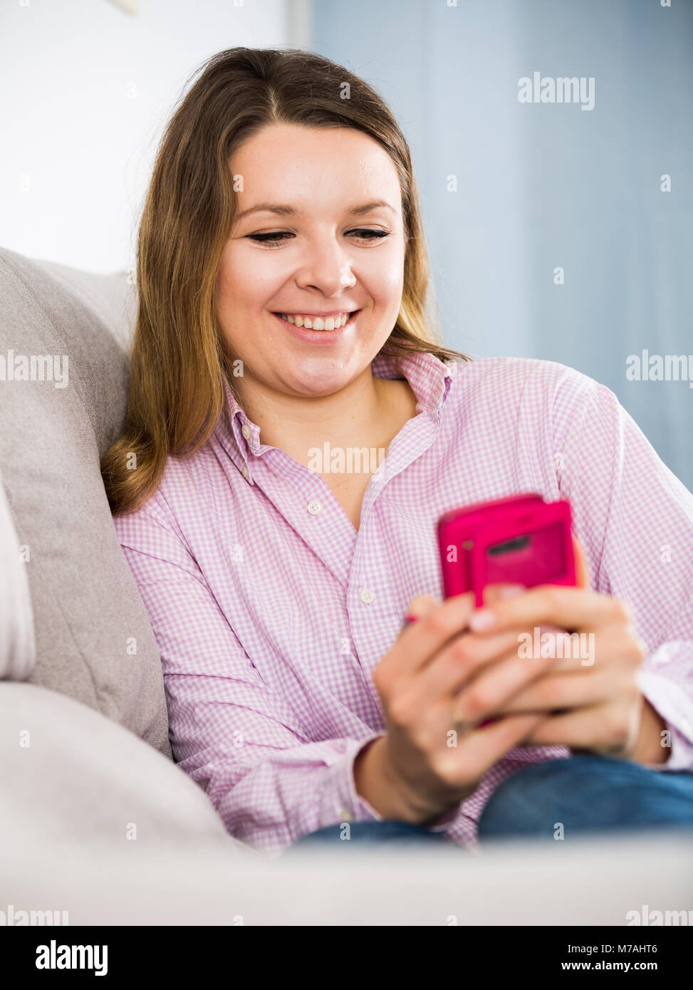 Smiling girl texting with her phone and taking photos at home Stock ...