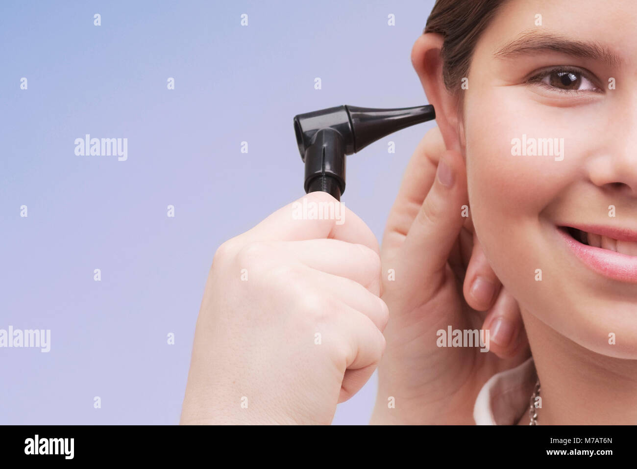 Female doctor examining a girls ear with an otoscope hi-res stock ...