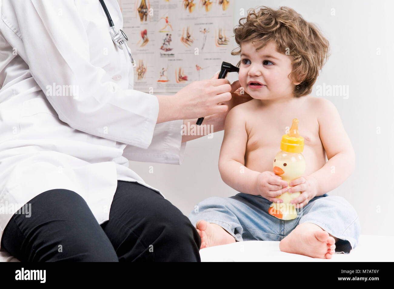 Female doctor examining a baby boy's ear with an otoscope Stock Photo ...