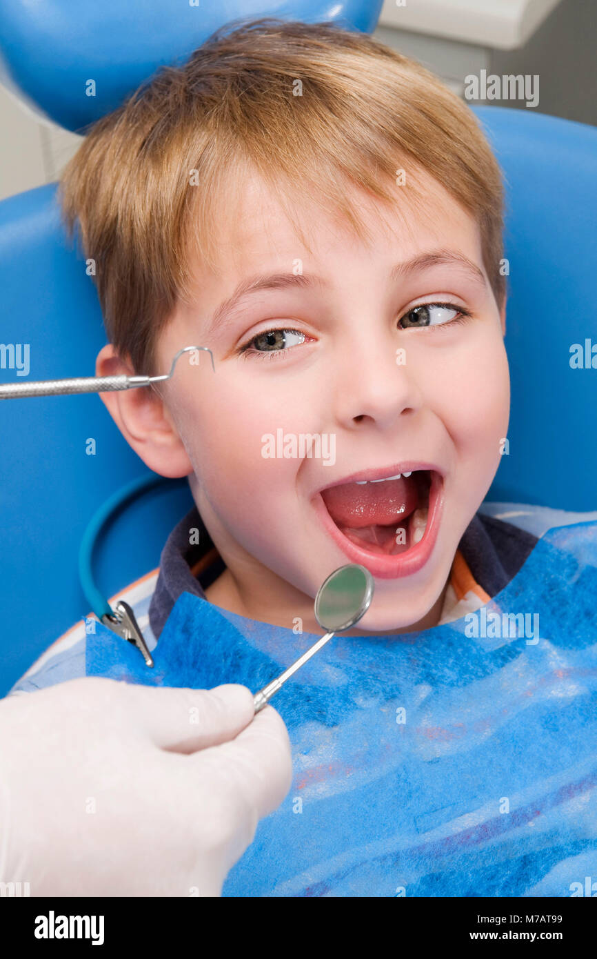 Dentist examining a boy's teeth Stock Photo - Alamy