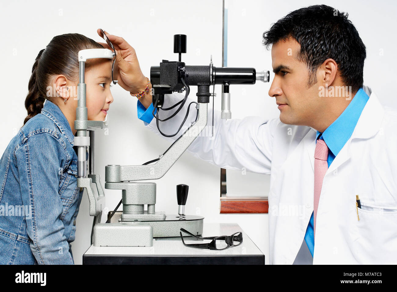 Side profile of an optometrist examining a girl's eye Stock Photo - Alamy