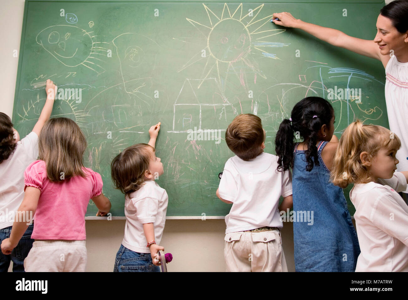 Female teacher teaching her students in a classroom Stock Photo - Alamy