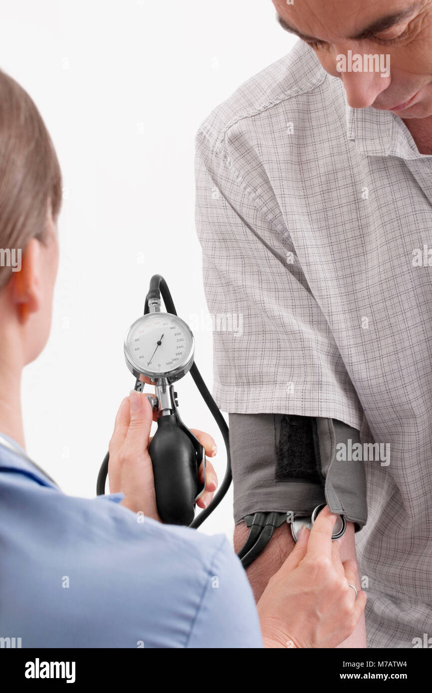 Female doctor checking blood pressure of a patient Stock Photo - Alamy
