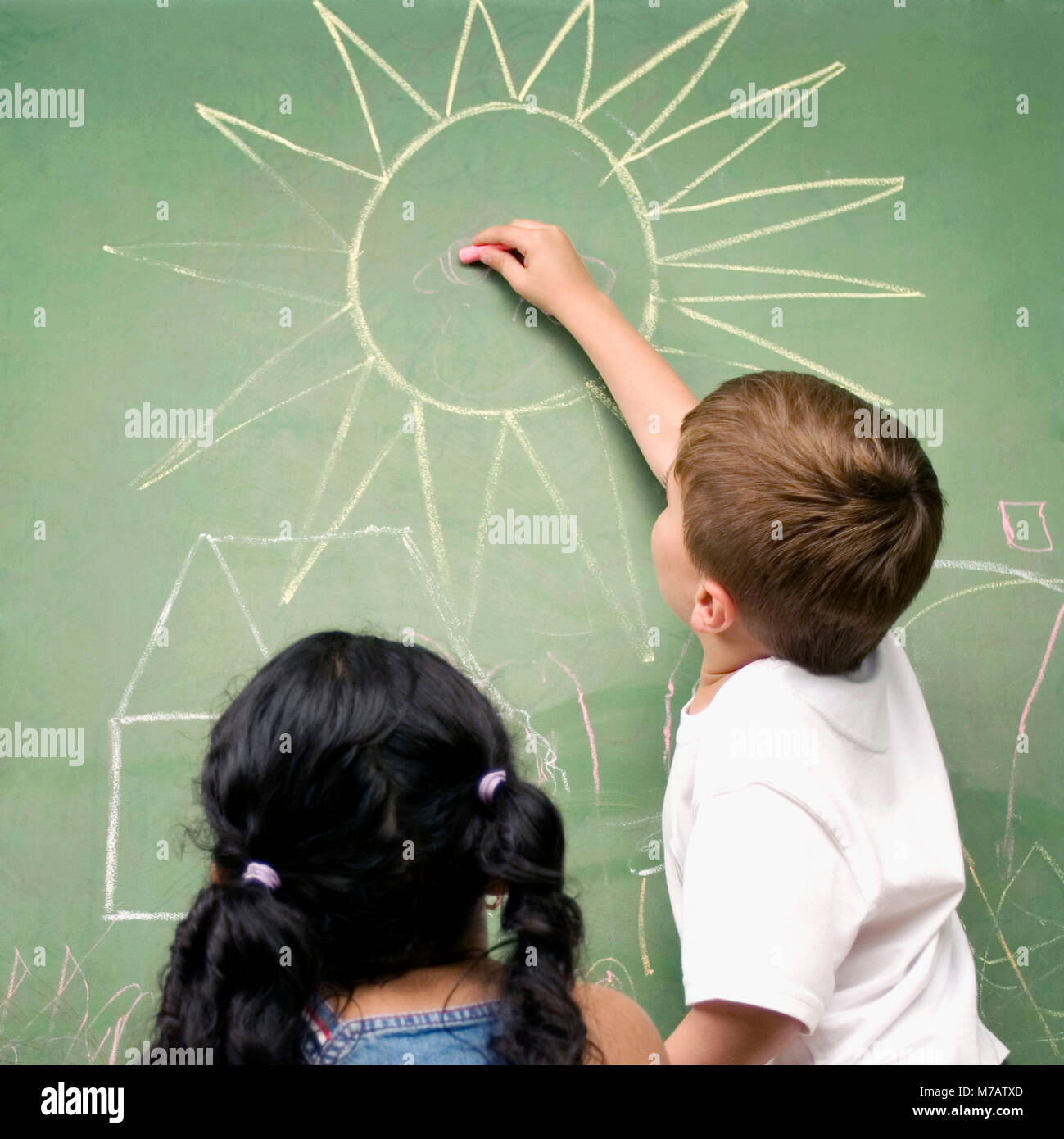 Two students drawing on a blackboard Stock Photo - Alamy