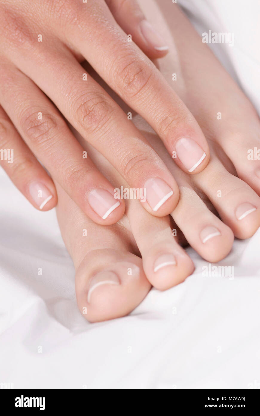 Close-up of a woman's hand touching her feet Stock Photo - Alamy
