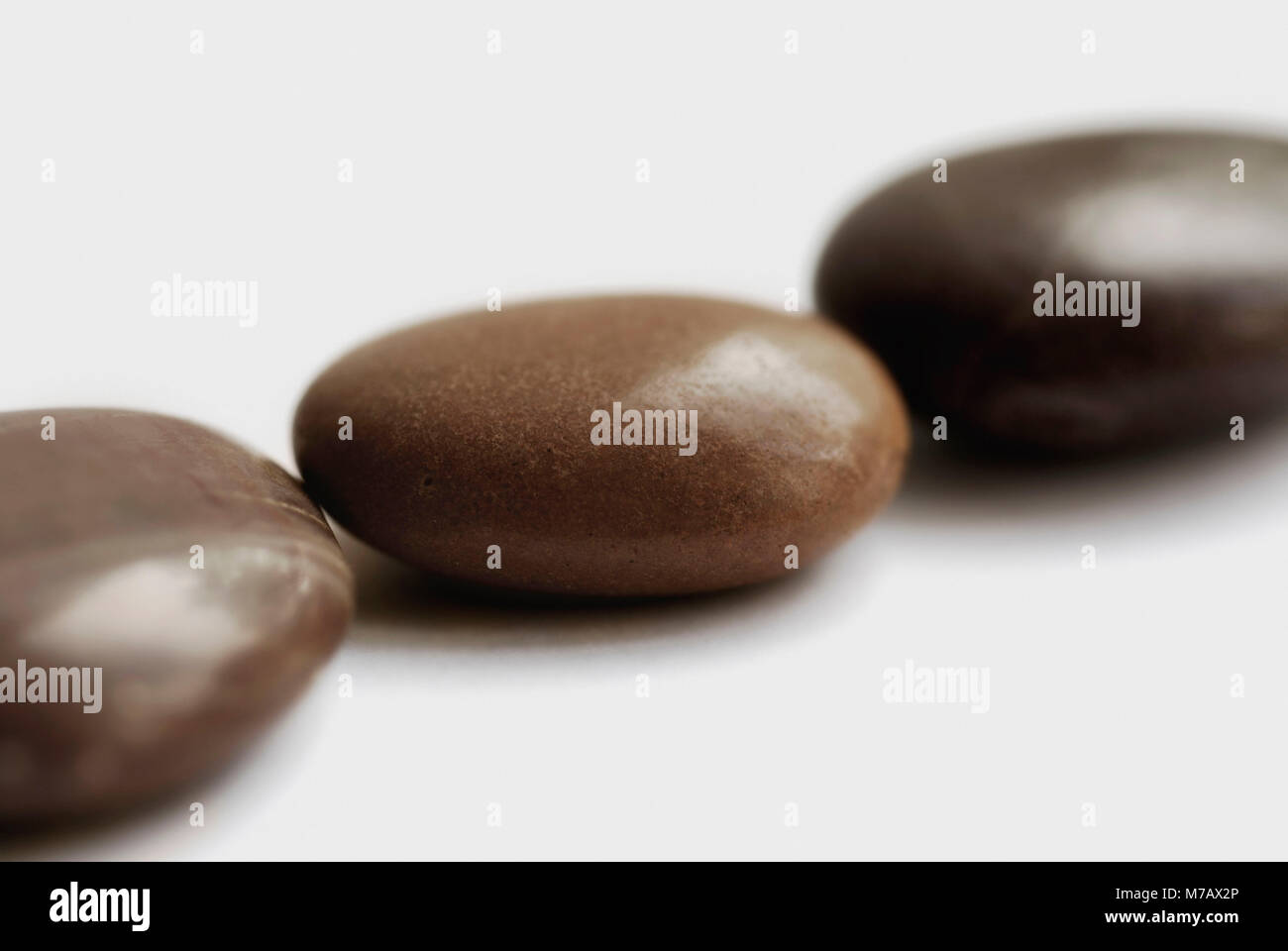 Close-up of three pebbles in a row Stock Photo - Alamy
