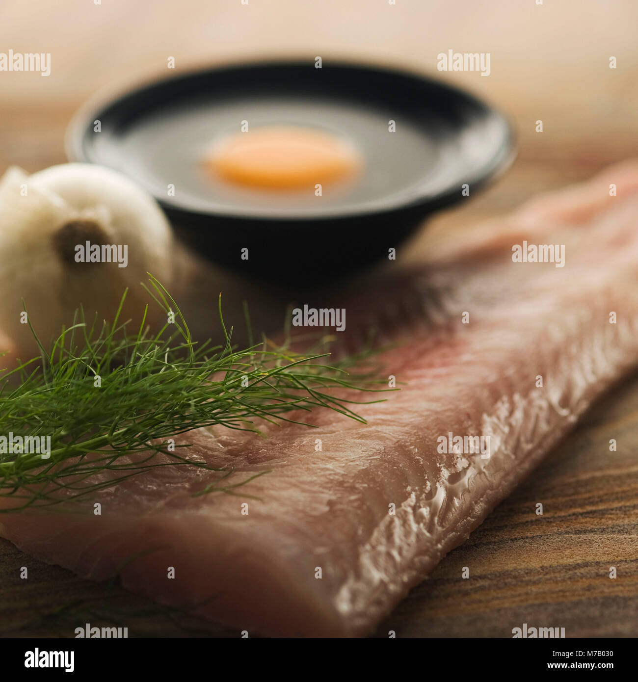 Slice of fish with egg yolk and onion Stock Photo - Alamy