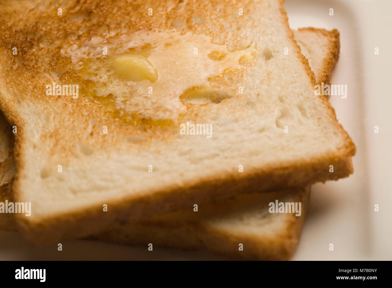 Two slices of toast with butter on a plate Stock Photo - Alamy