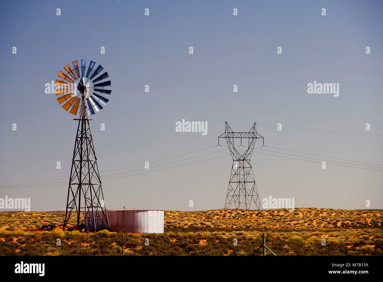 Industrial windmill with an electricity pylon in the background ...