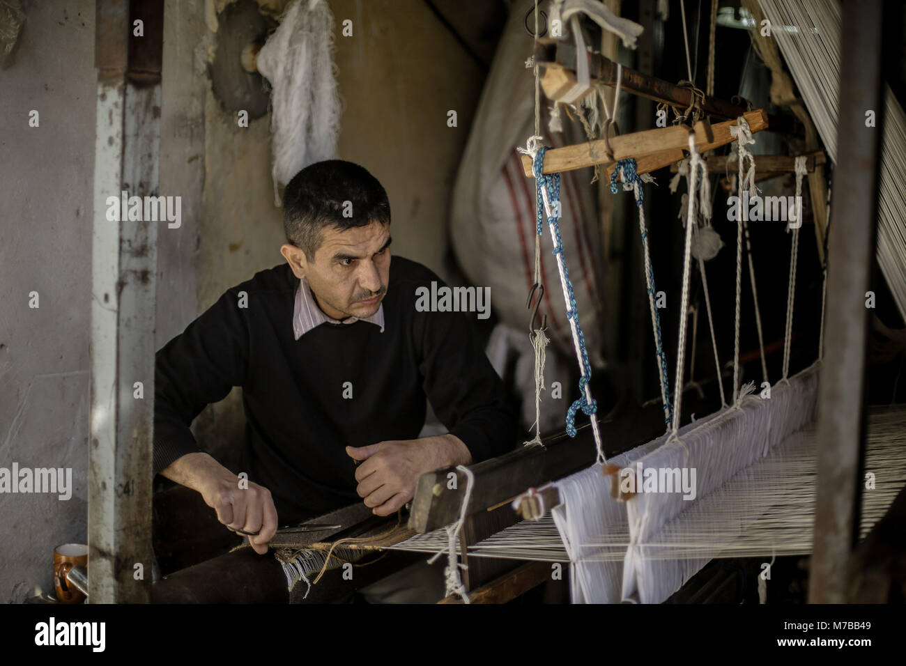 dpatop - A Palestinian man hand-weaves a carpet on a manual loom in ...